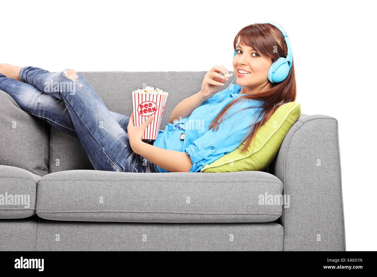 Girl listening music and eating popcorn on sofa isolated on white ...