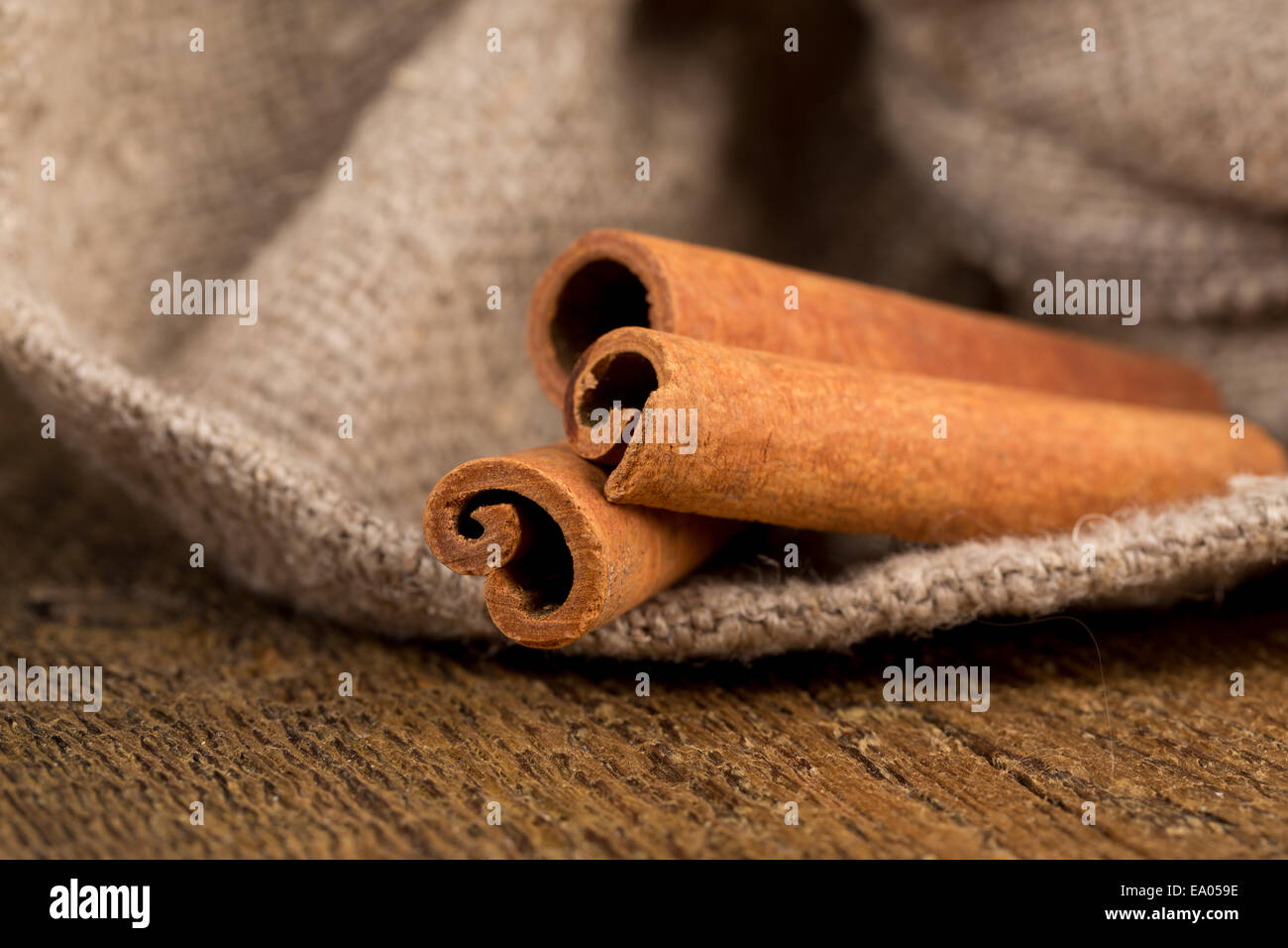 cinnamon sticks on hessian canvas with wooden background Stock Photo ...