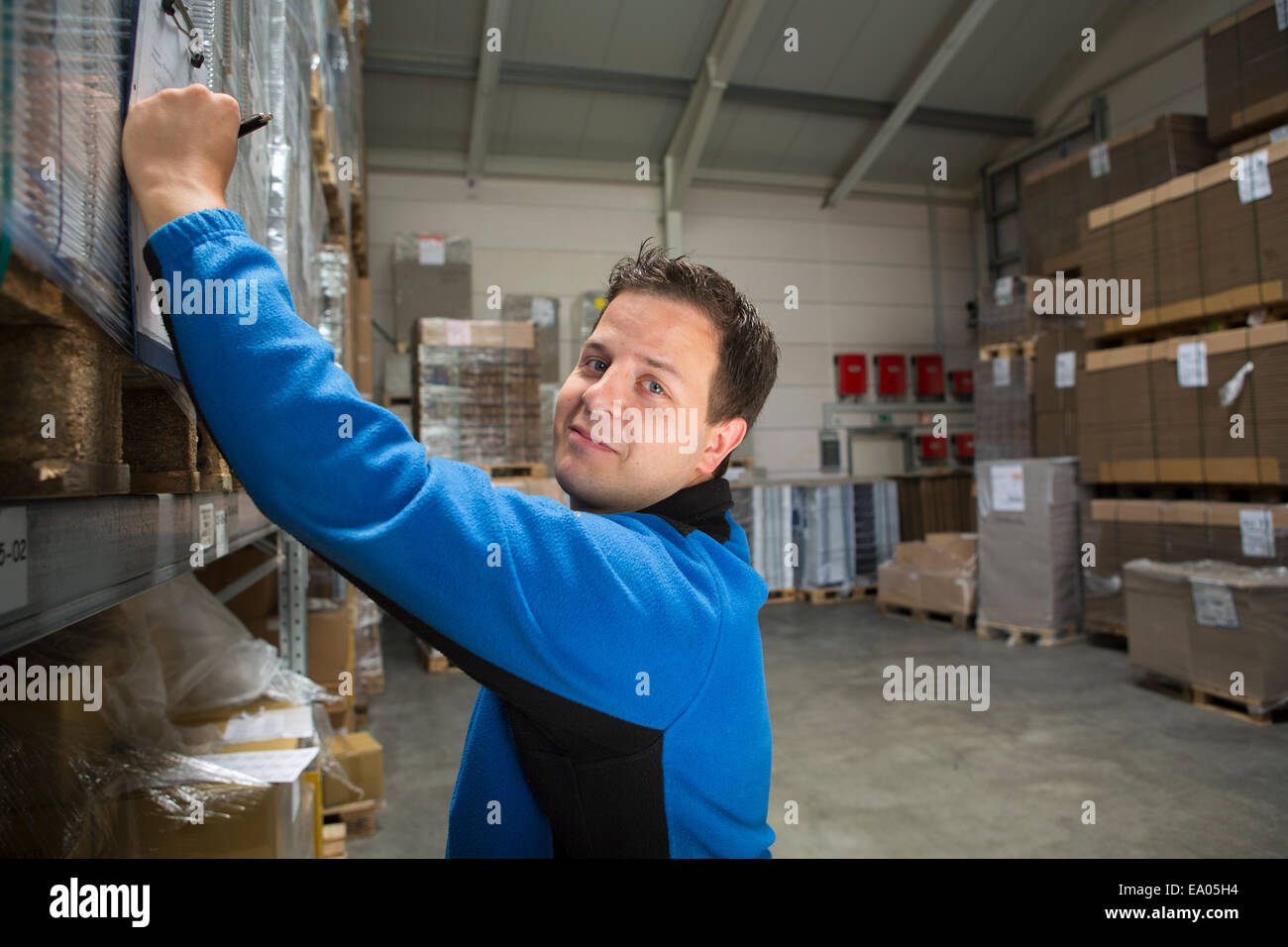 Factory worker checking pallets Stock Photo - Alamy