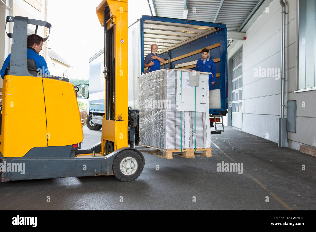 Factory worker operating forklift Stock Photo - Alamy