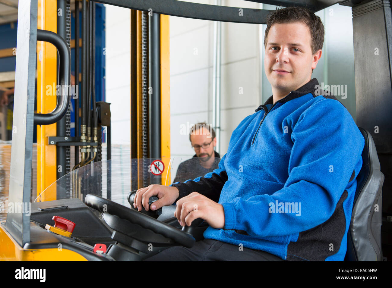 Factory worker operating forklift Stock Photo - Alamy