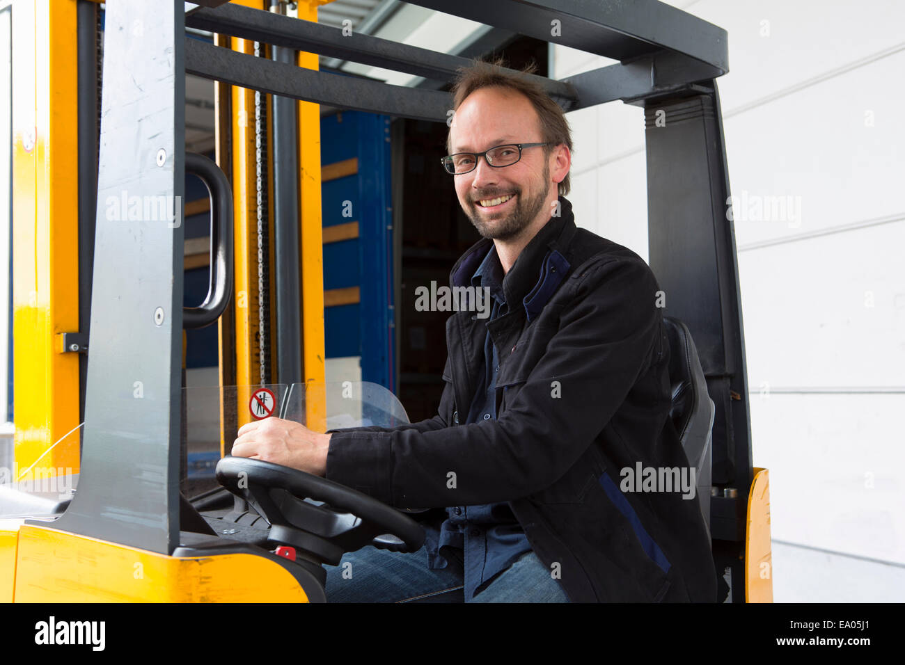 Factory worker operating forklift Stock Photo - Alamy