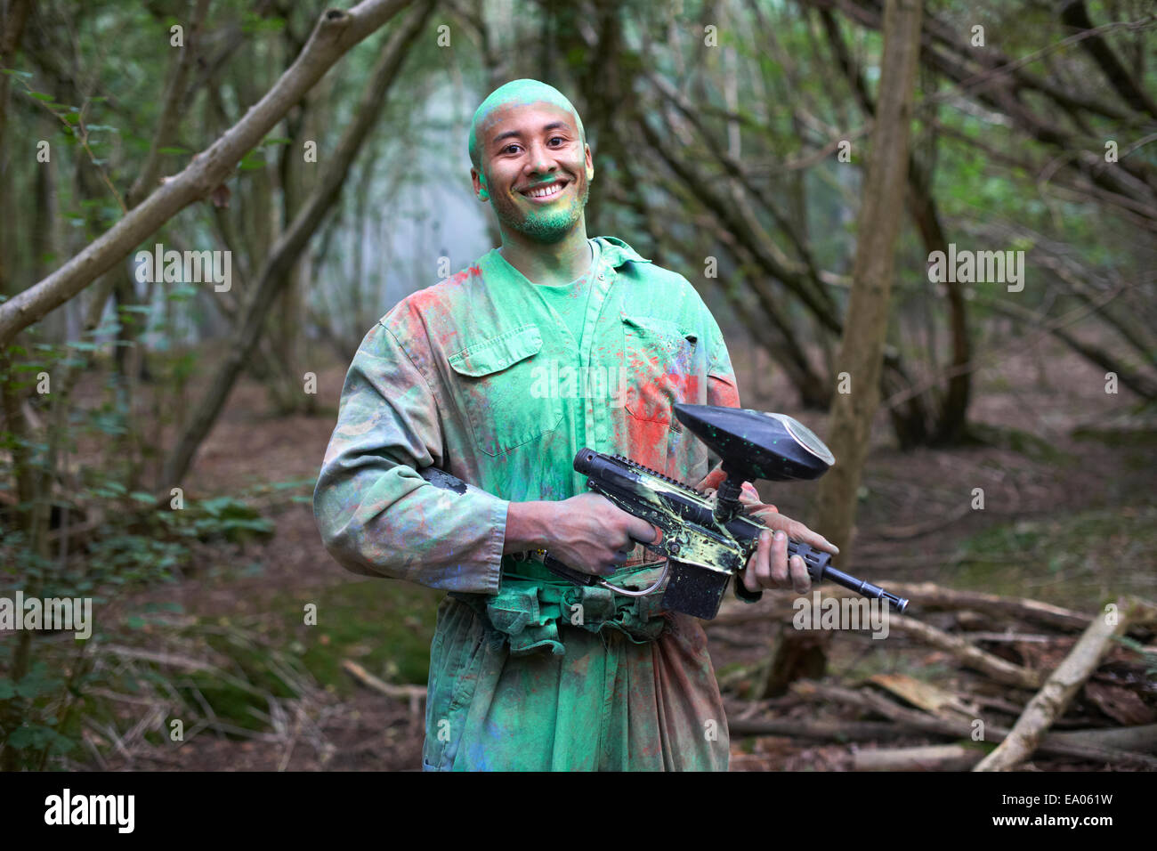 Paintball player in paintball wear marked with paint Stock Photo - Alamy