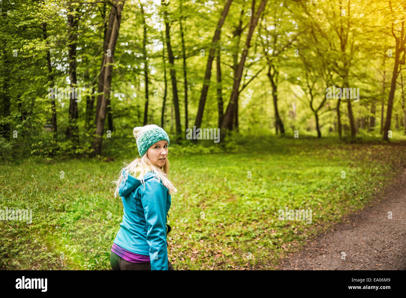 Young woman walking in forest looking back over her shoulder Stock ...
