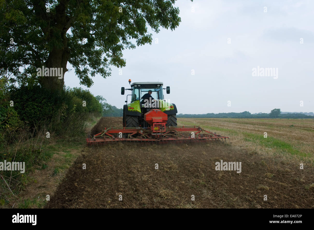 Farmer driving tractor and planting seed corn in field Stock Photo - Alamy