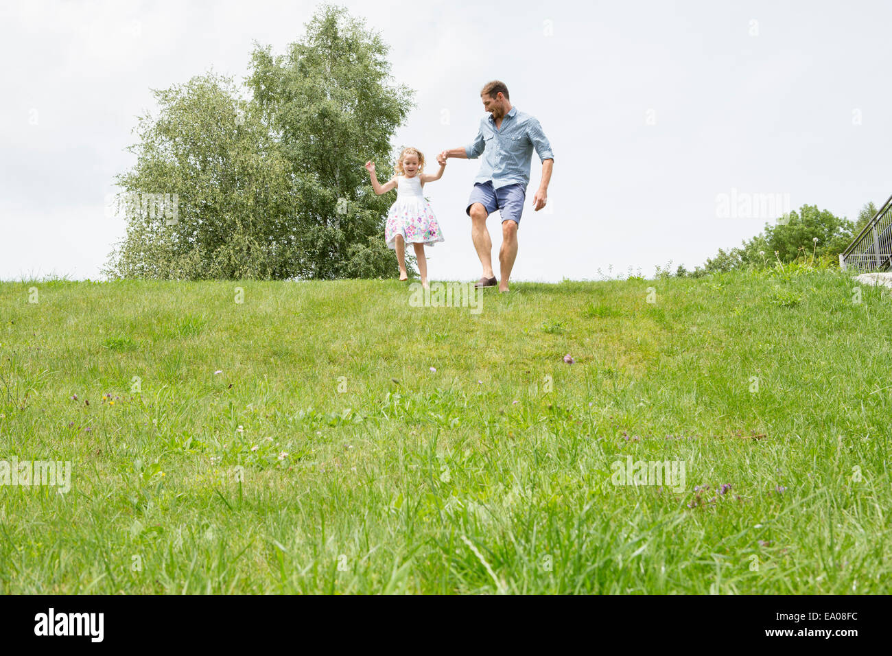Father and daughter running downhill Stock Photo - Alamy