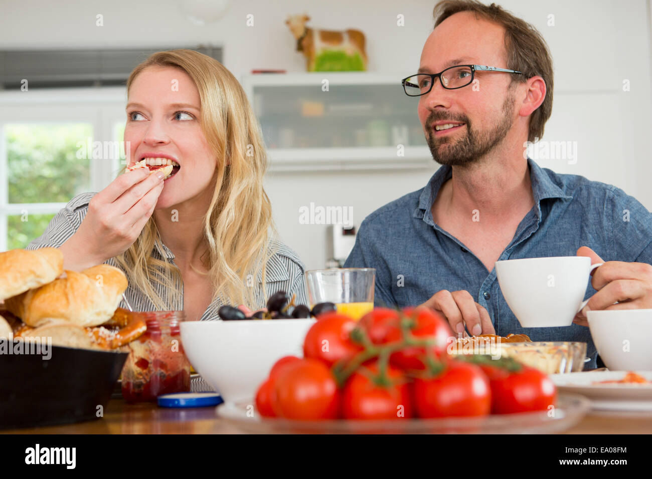 Couple eating at kitchen table Stock Photo - Alamy