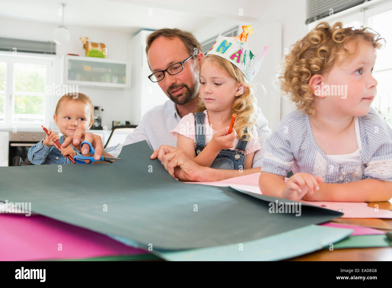 Family making paper crowns Stock Photo - Alamy