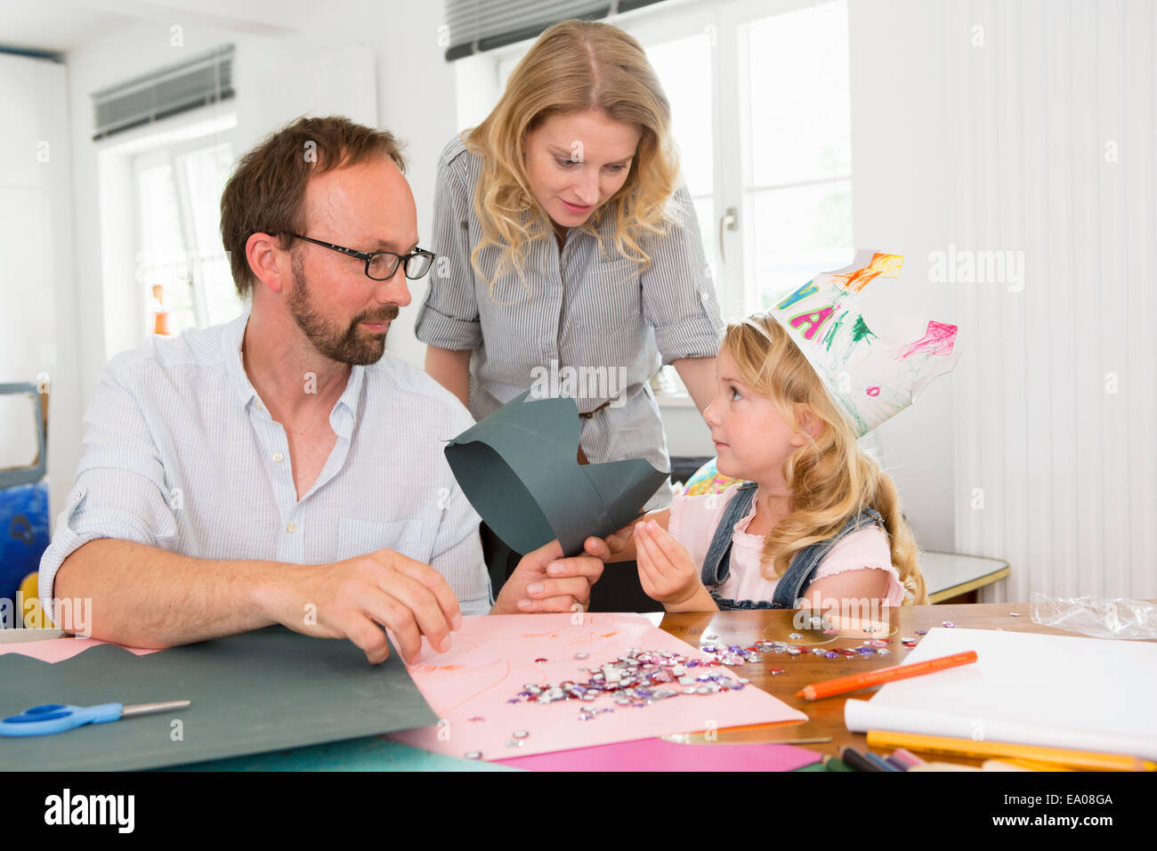 Family making paper crowns Stock Photo - Alamy