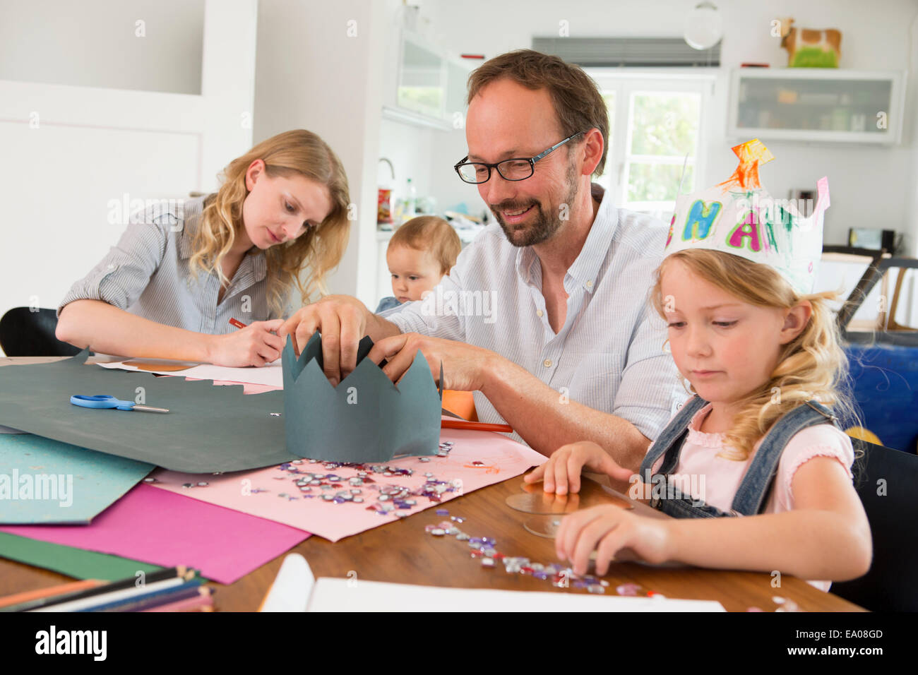 Family making paper crowns Stock Photo - Alamy