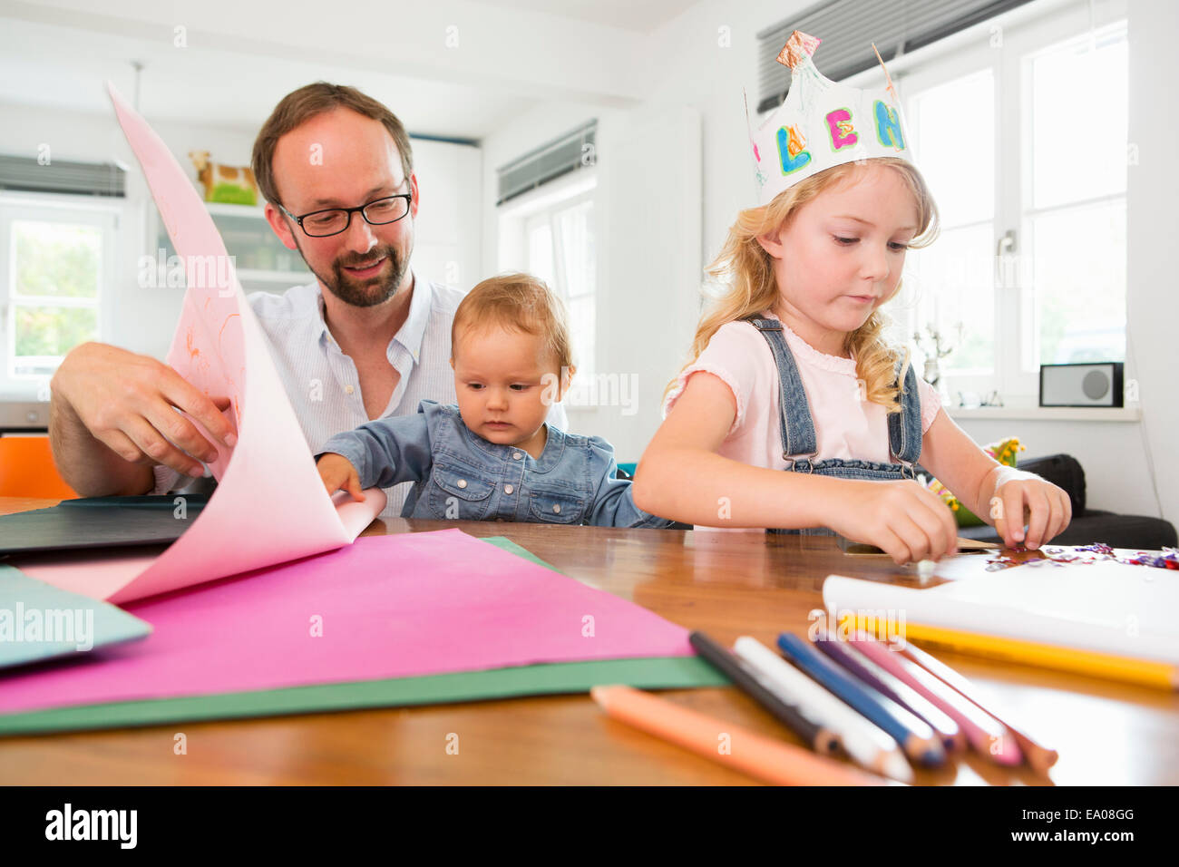 Family making paper crowns Stock Photo - Alamy