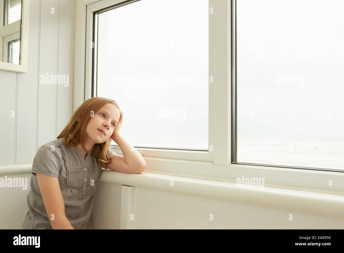 Portrait of girl gazing out of holiday apartment window Stock Photo - Alamy
