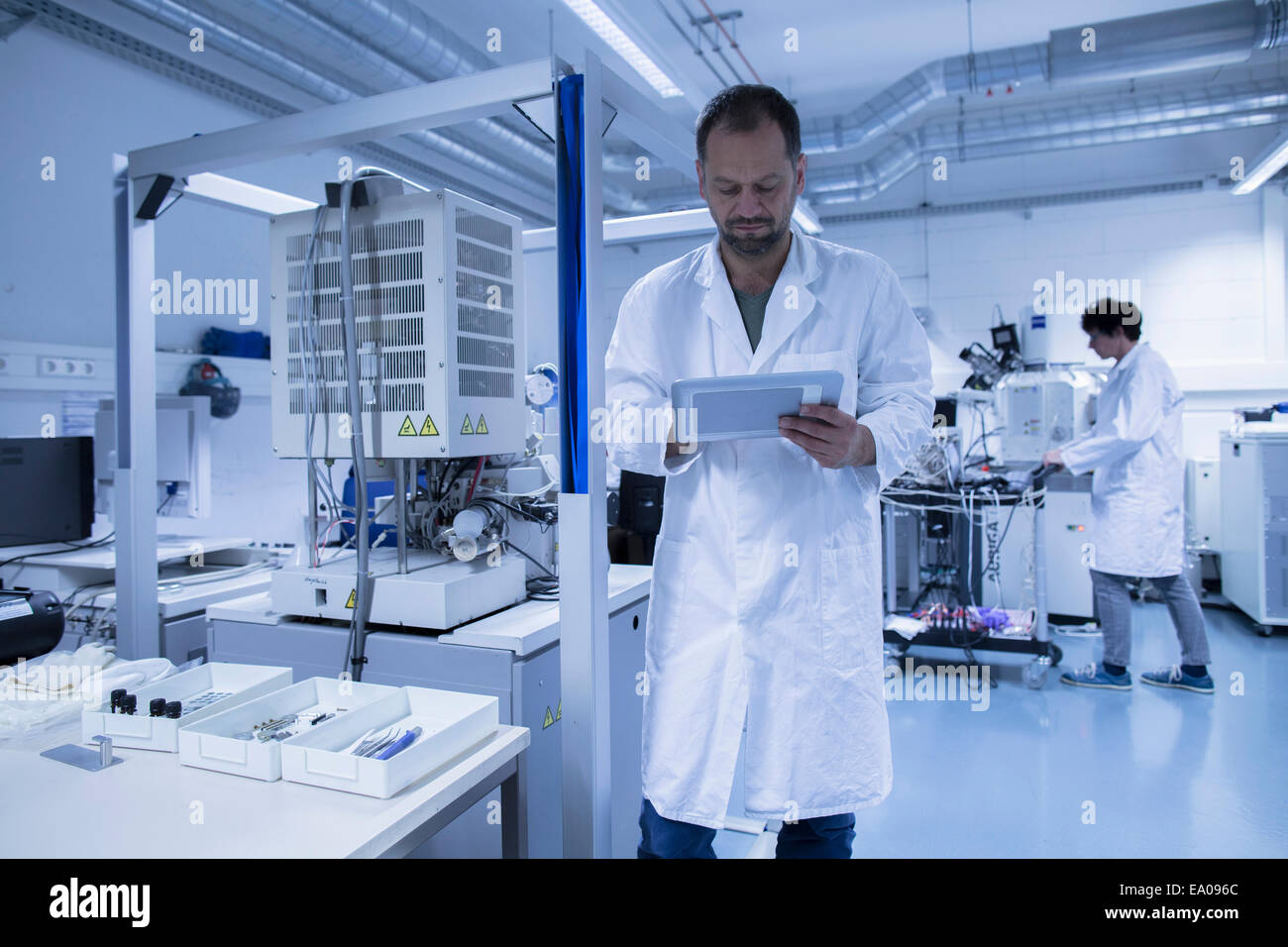 Lab assistant checking details on digital tablet Stock Photo - Alamy