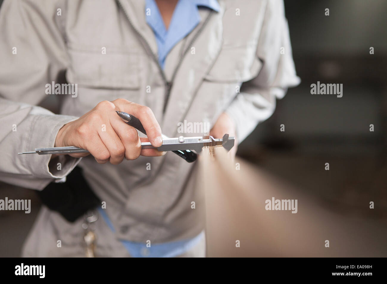 Carpenter measuring wood plank with vernier caliper in factory, Jiangsu ...