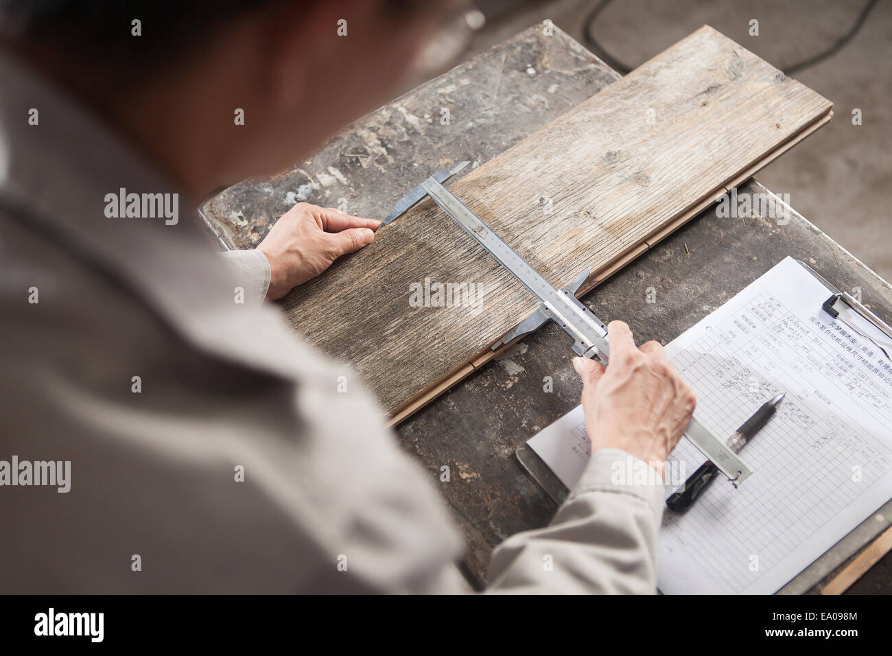 Carpenter measuring wood plank with vernier caliper in factory, Jiangsu ...