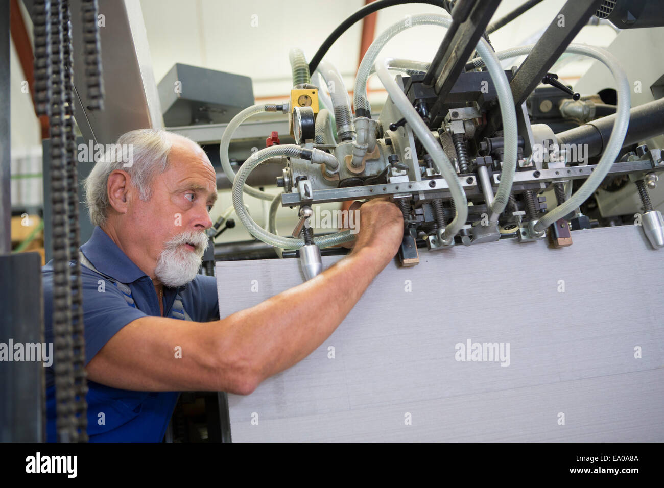 Factory worker working machinery Stock Photo - Alamy
