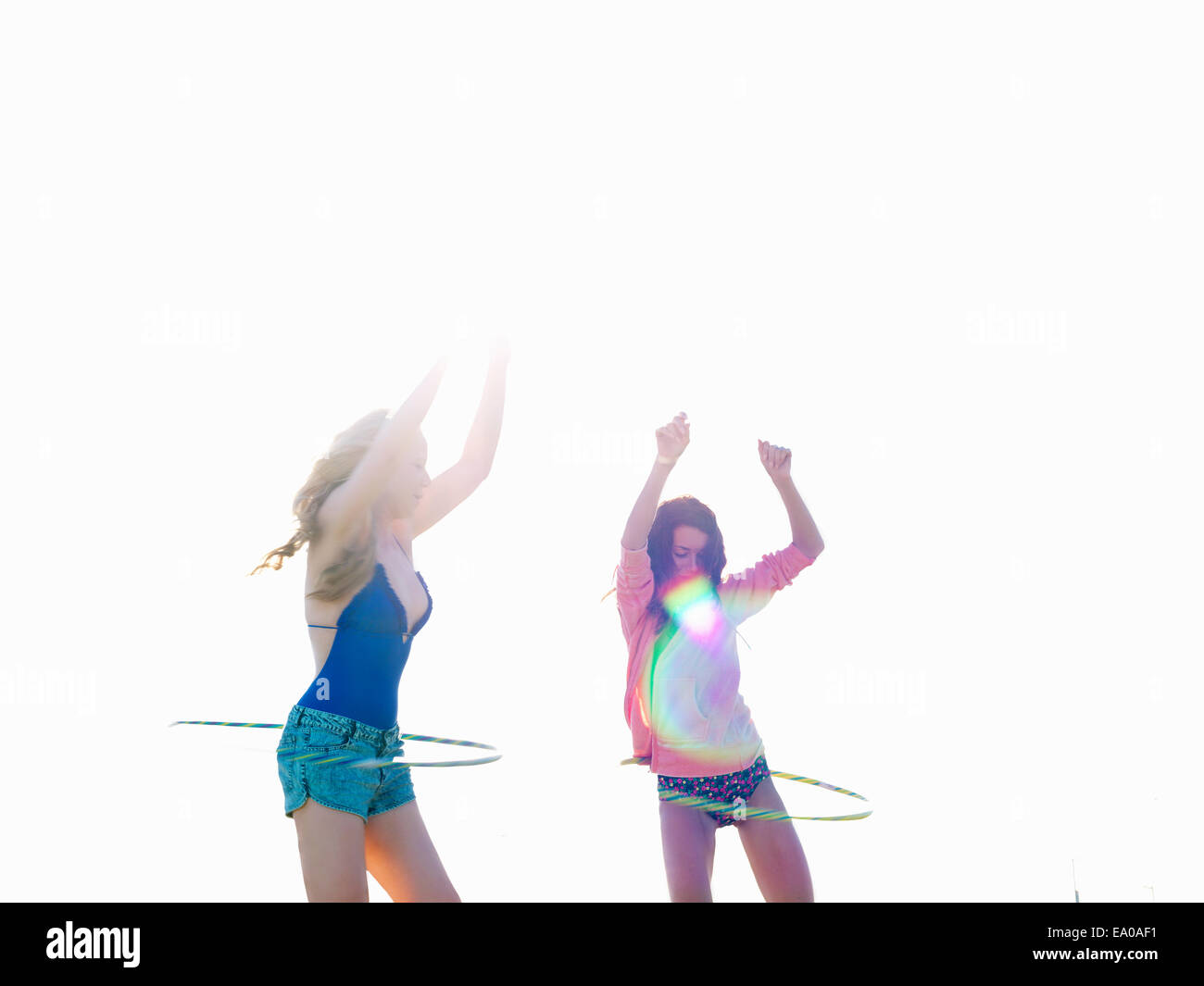 Two young women friends swinging hoola hoops on beach, Williamstown ...