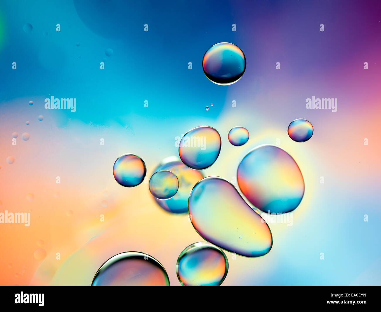 macro of oil drops on water surface with vibrant colors in background ...