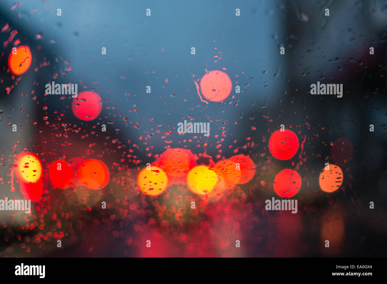 Night driving in the rain through the windshield watching the red ...