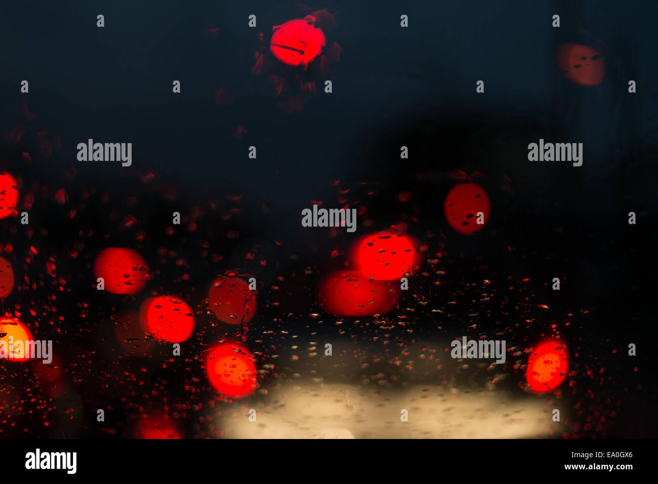 Night driving in the rain through the windshield watching the red ...