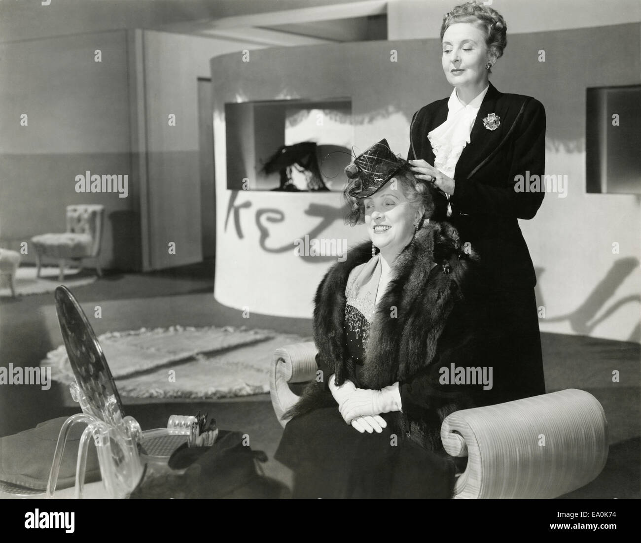 Adjusting her new hat Stock Photo - Alamy