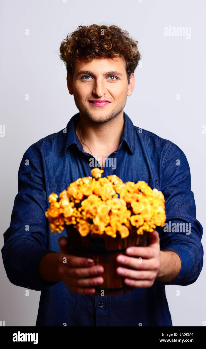 Happy man holding bucket with flowers Stock Photo - Alamy