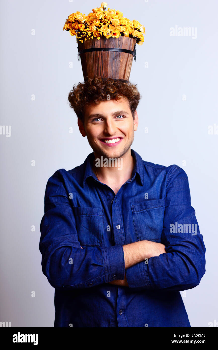 Happy man with a bucket on his head with flowers Stock Photo - Alamy