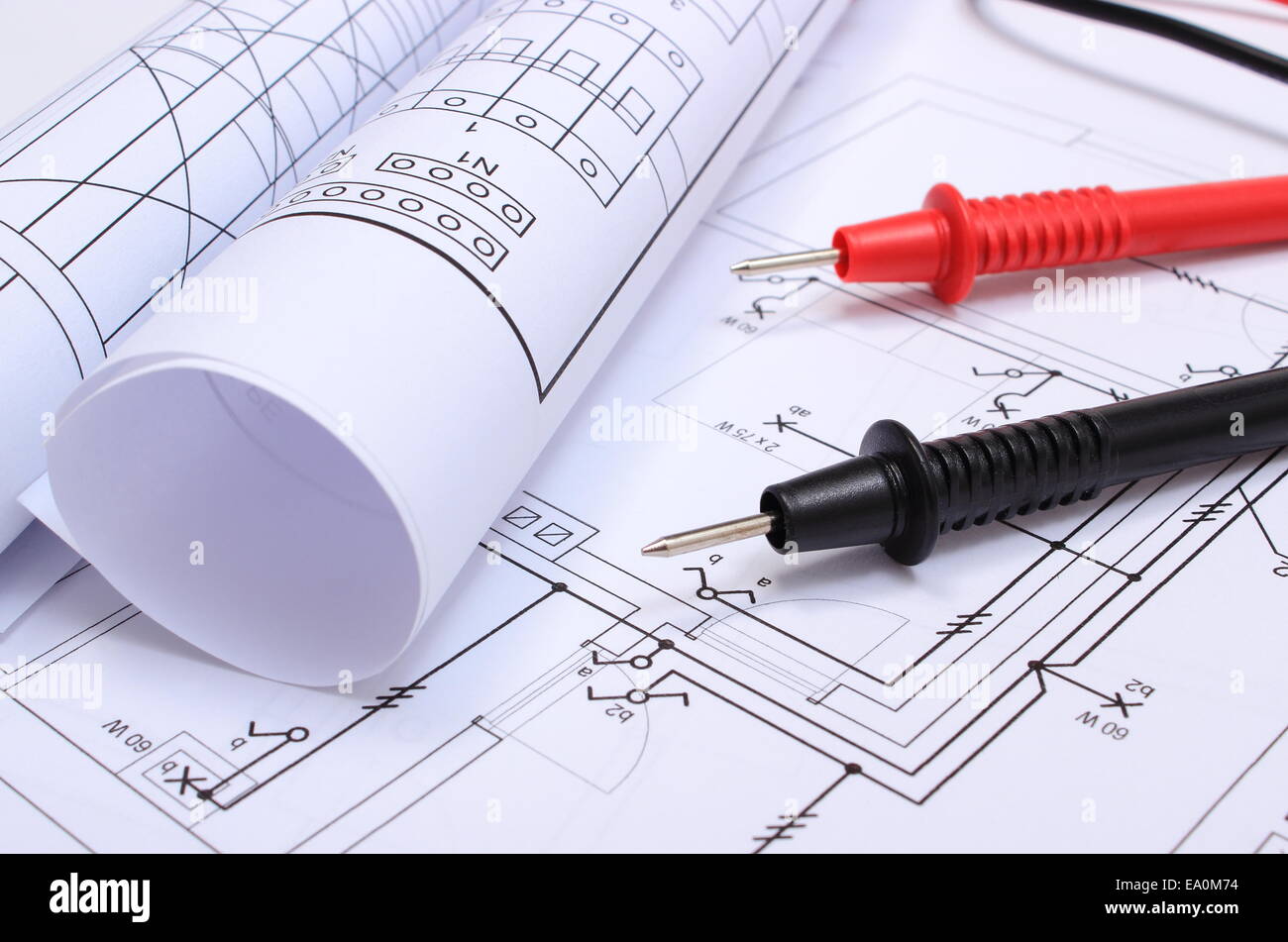 Rolls of electrical diagrams and cables of multimeter lying on ...