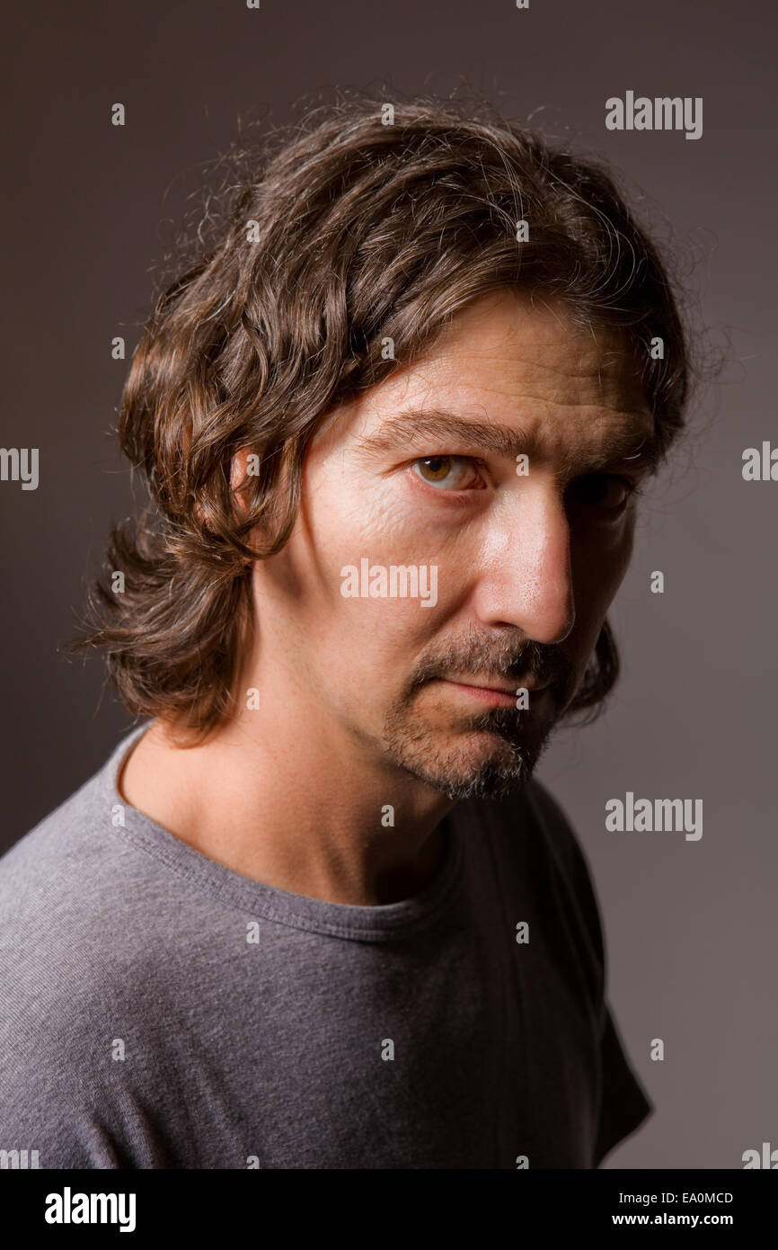 Portrait of young man thinking on a black background Stock Photo - Alamy