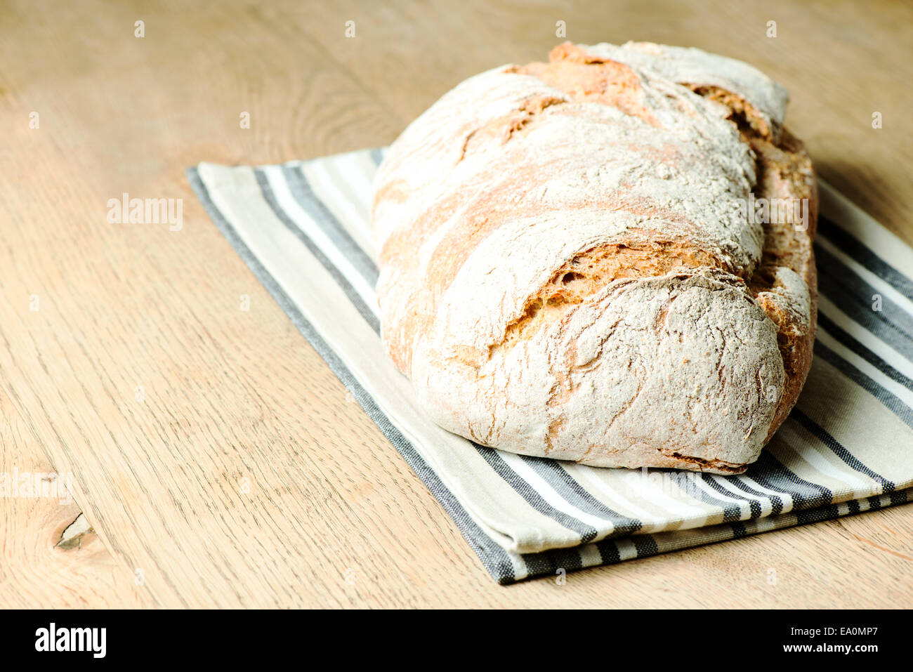 Large loaf of bread on wooden table Stock Photo - Alamy