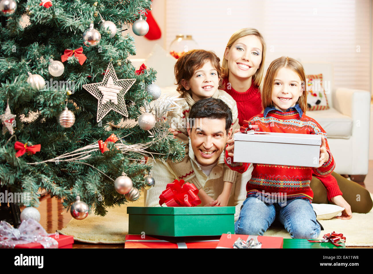 Happy family at home with christmas tree and gifts and children Stock ...
