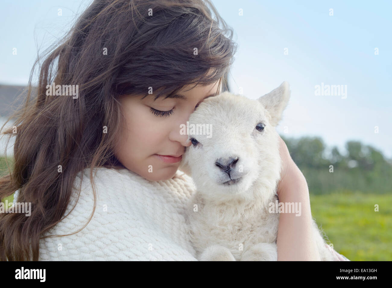 Portrait of young woman in field carrying lamb wrapped in blanket Stock ...
