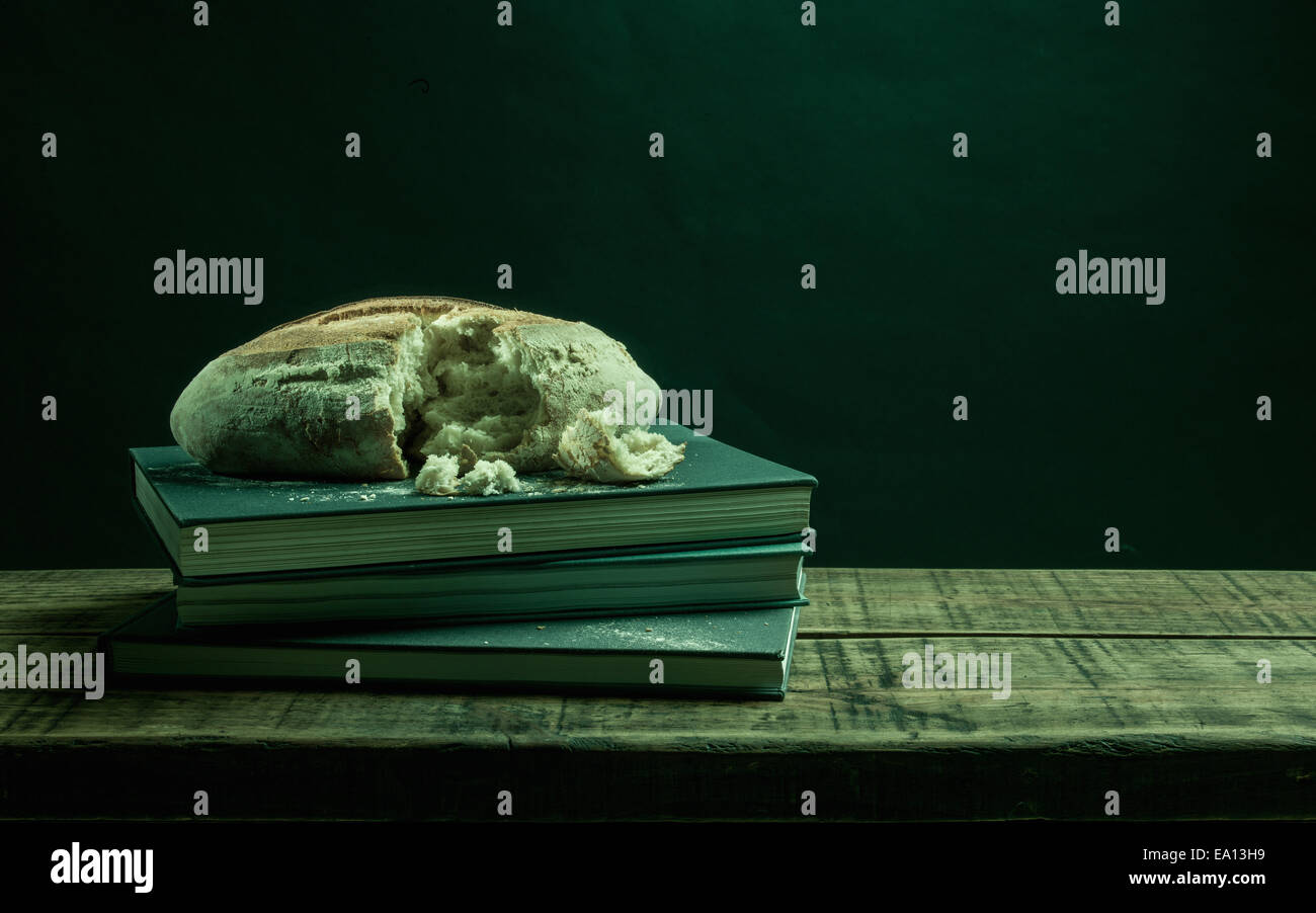 Still life of a stack of books and a loaf of bread Stock Photo - Alamy