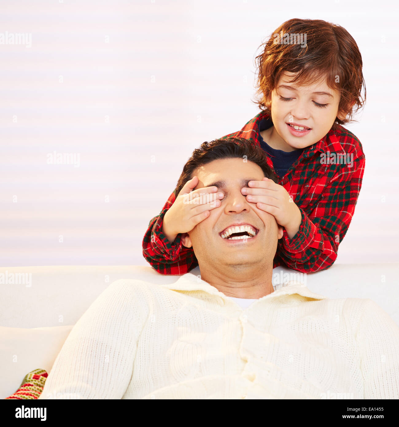 Child holding eyes of his laughing father closed Stock Photo - Alamy