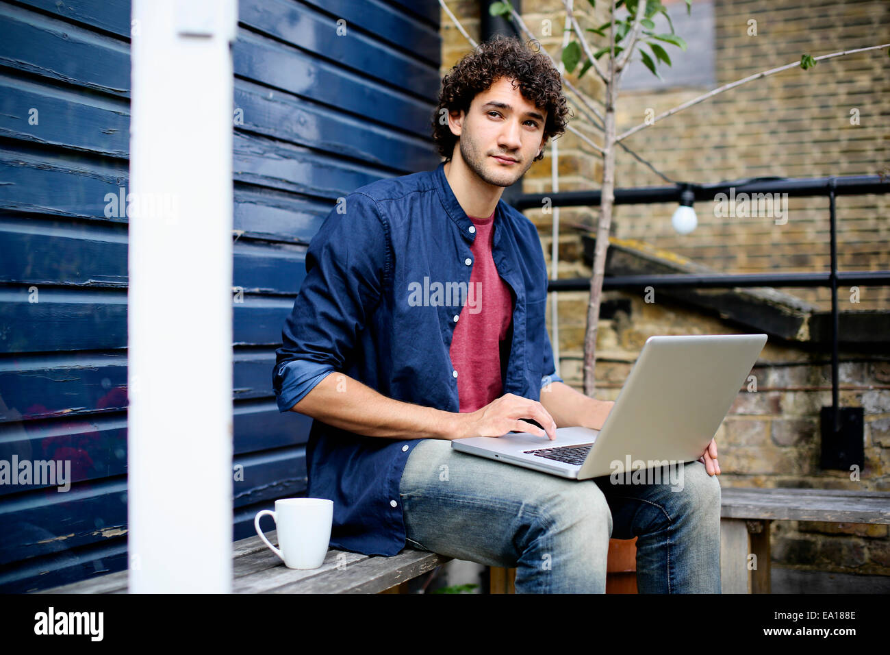 Man using laptop on bench Stock Photo - Alamy