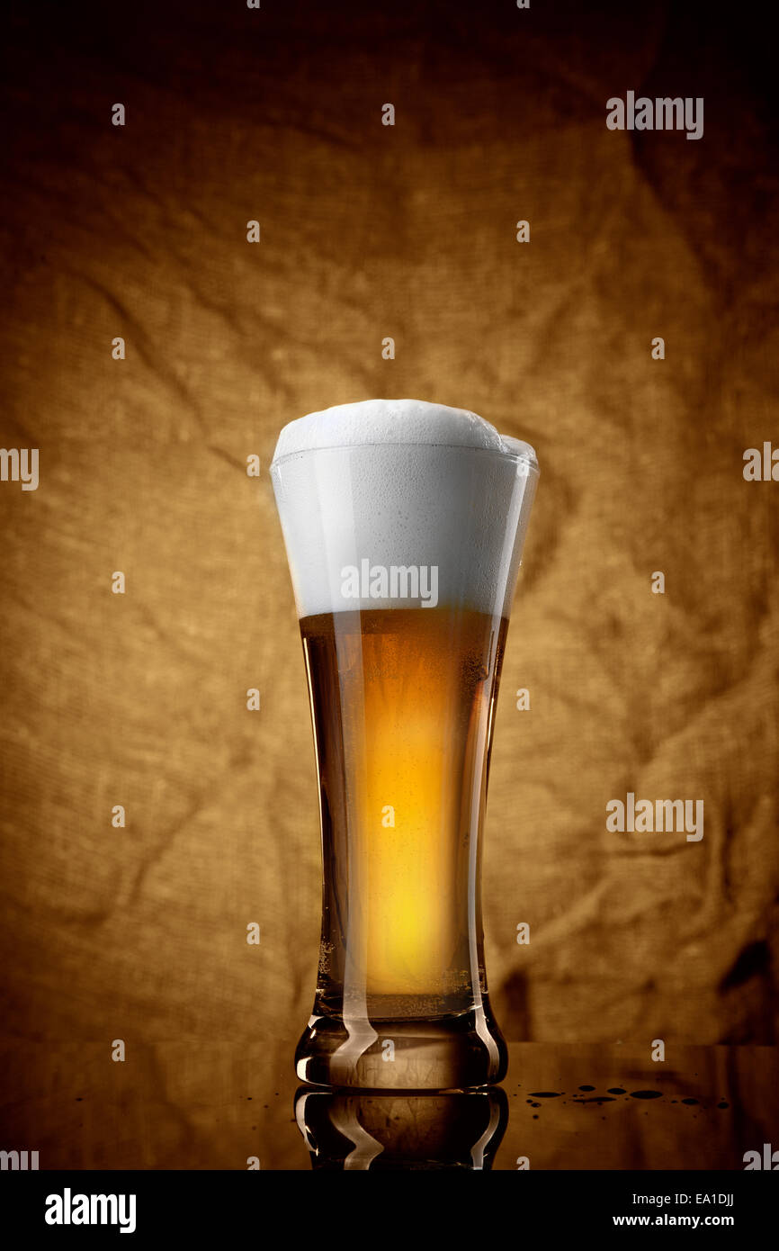 Beer in glass on brown background Stock Photo - Alamy