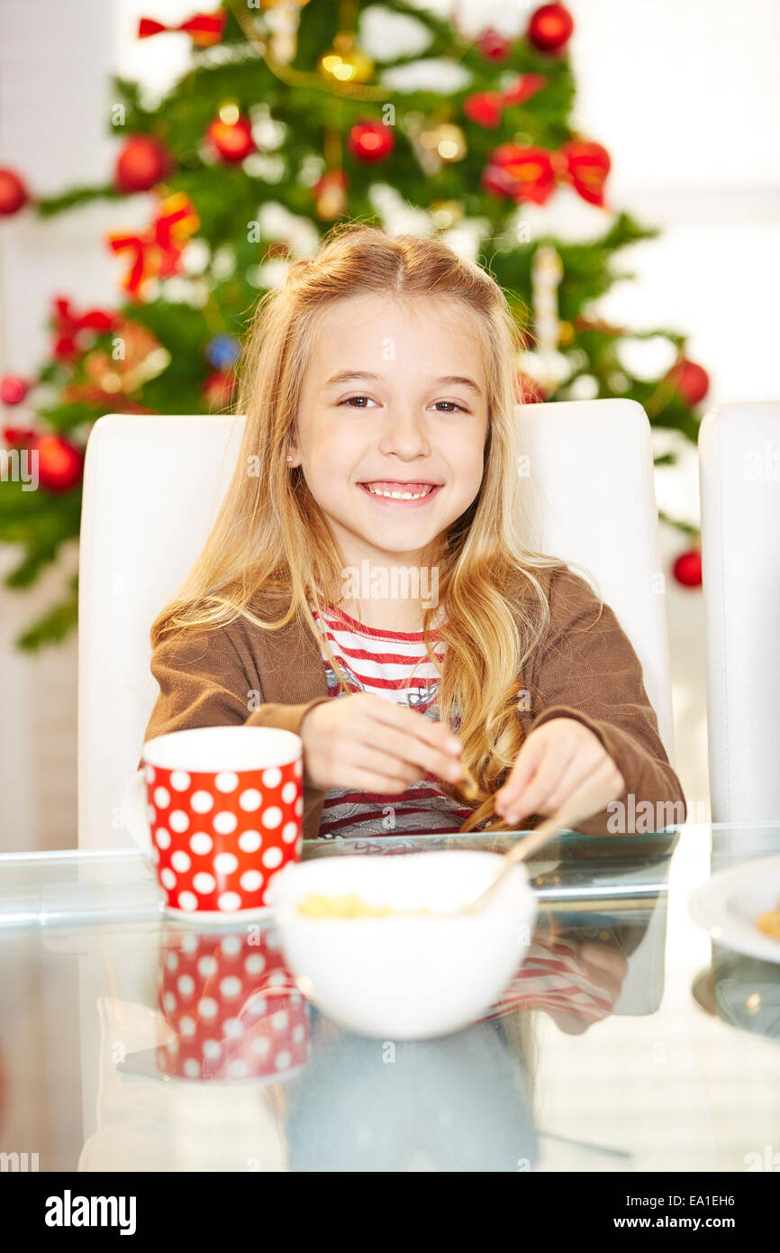 Happy smiling girl eating cookies at christmas Stock Photo - Alamy