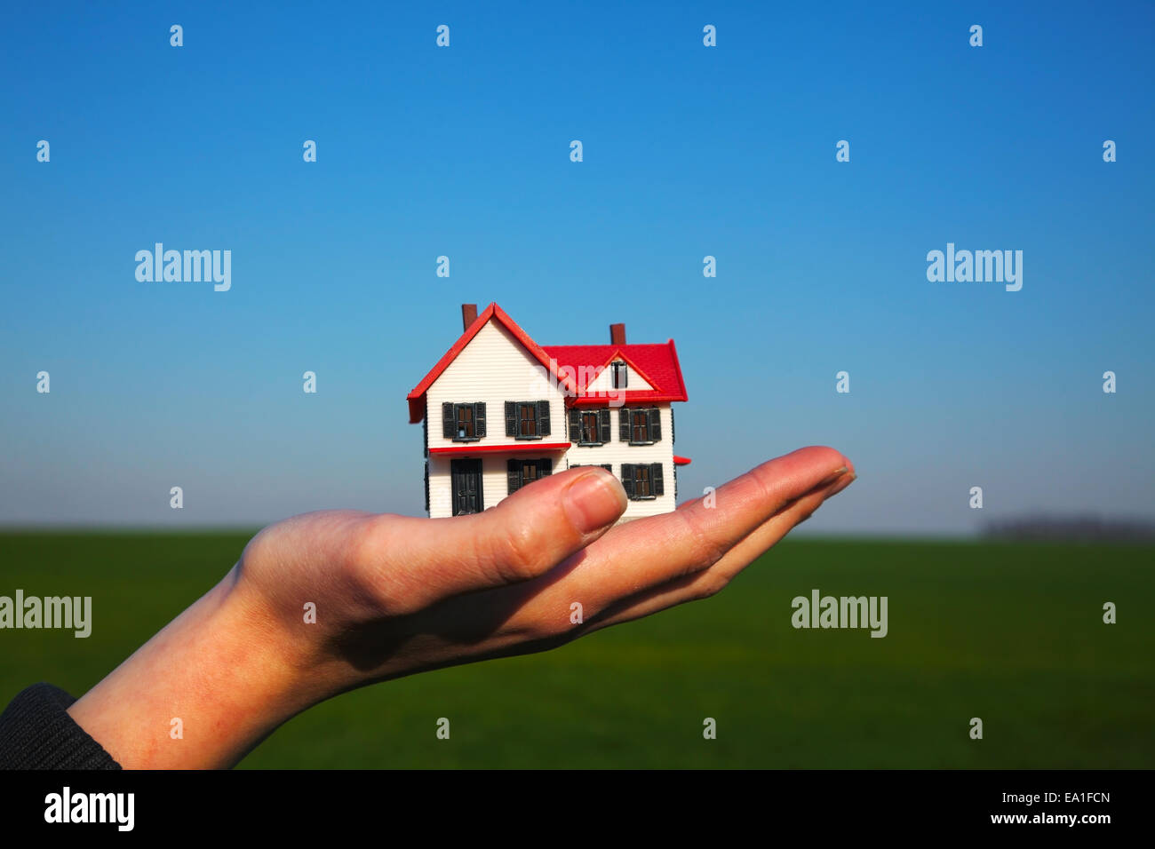 Female hand holding a model of building Stock Photo - Alamy