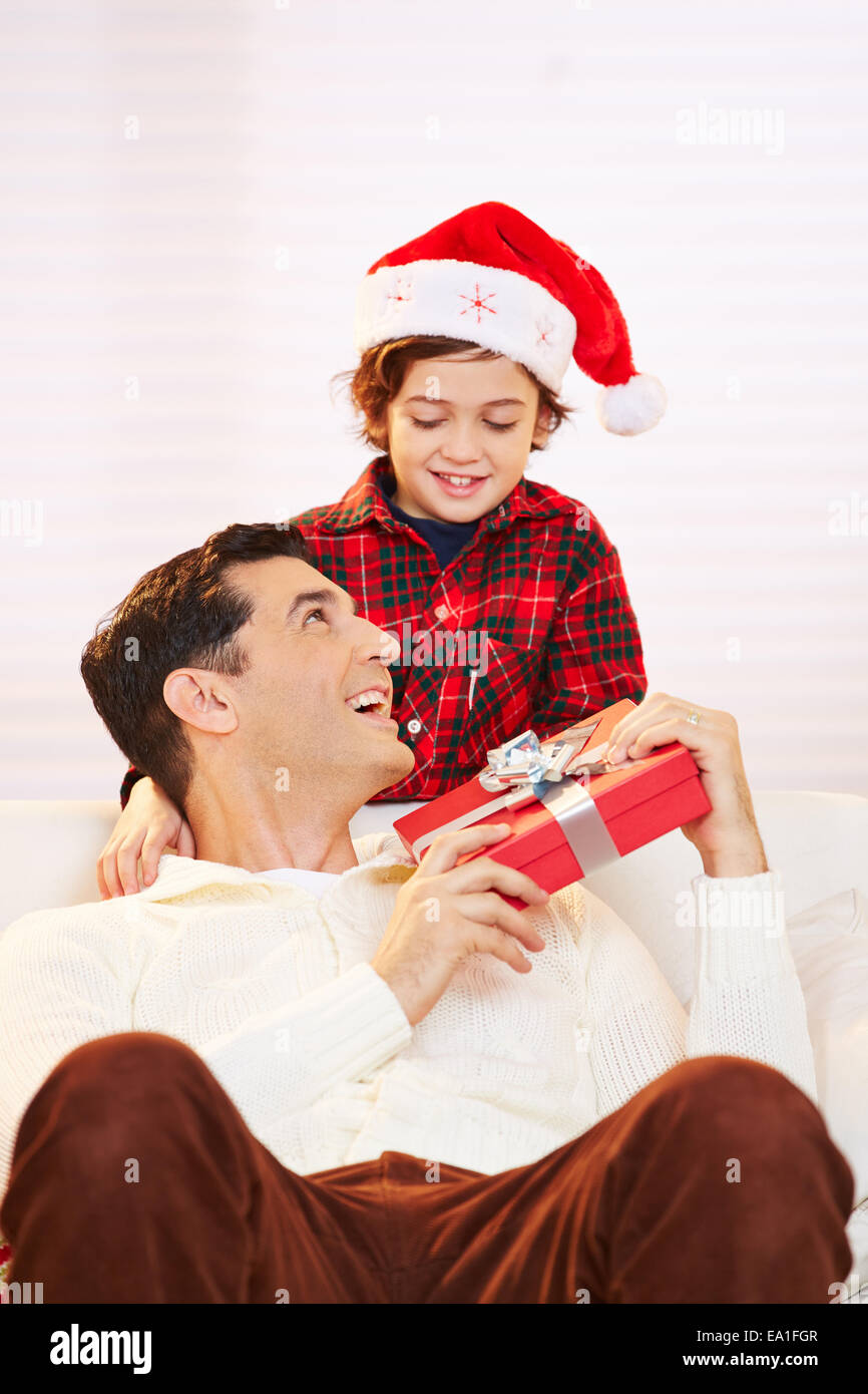 Son giving his father a gift at christmas eve Stock Photo - Alamy