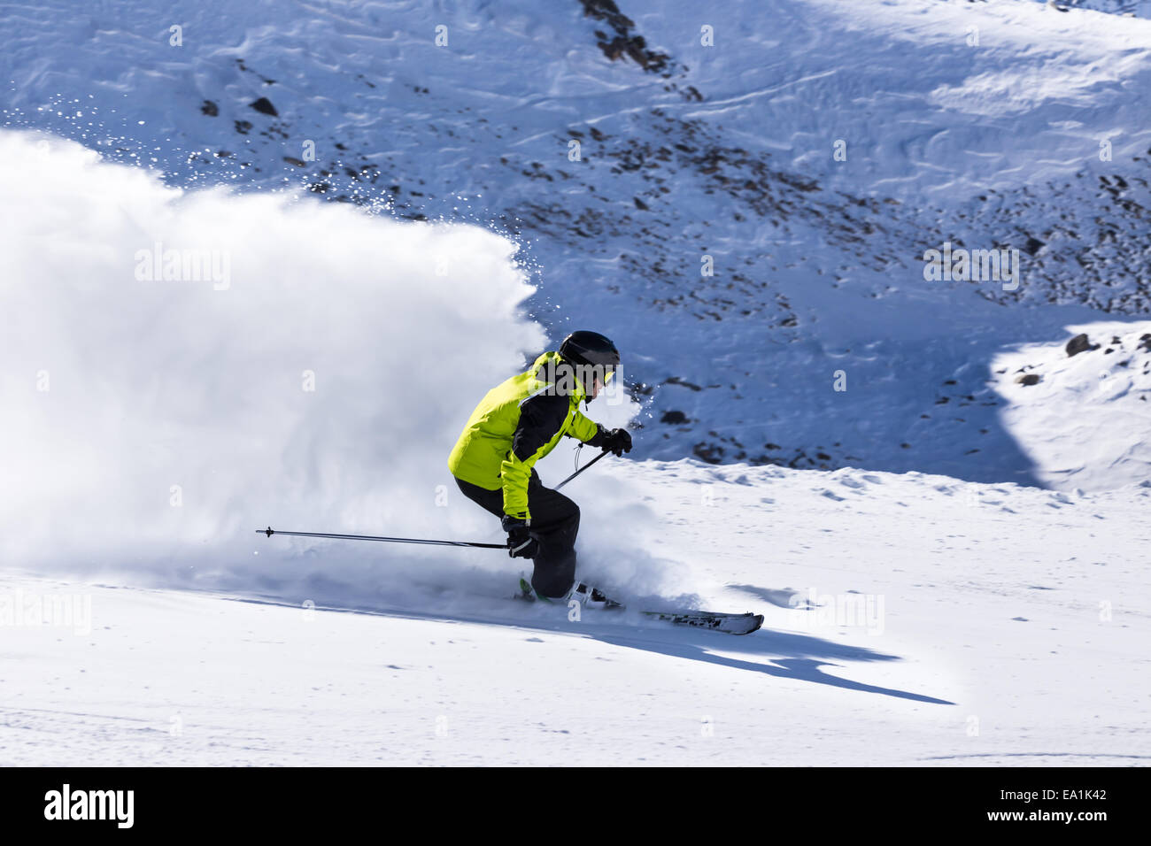 Alpine skier skiing downhill, blue sky on background Stock Photo - Alamy