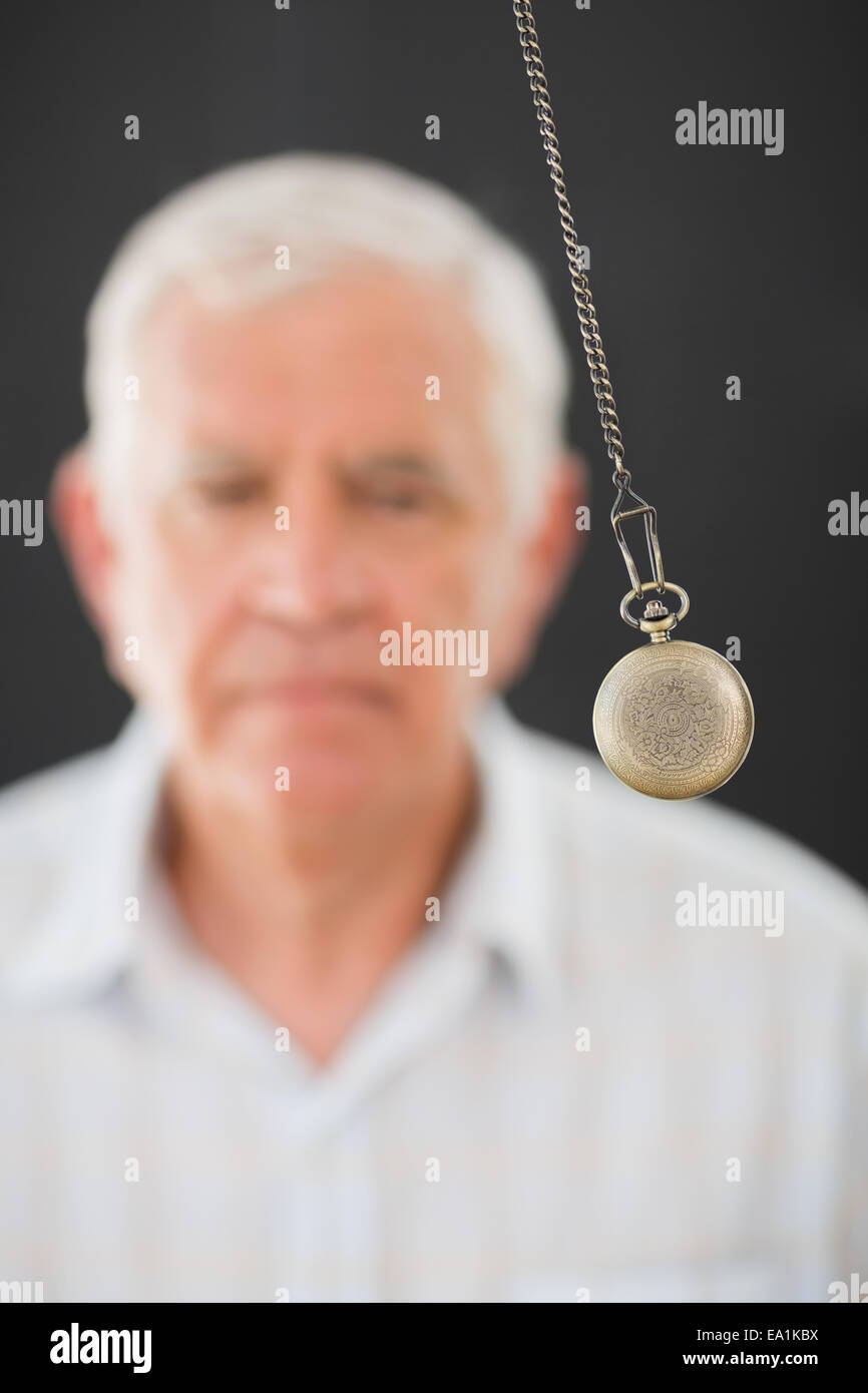 Senior man being hypnotized with pendulum Stock Photo - Alamy