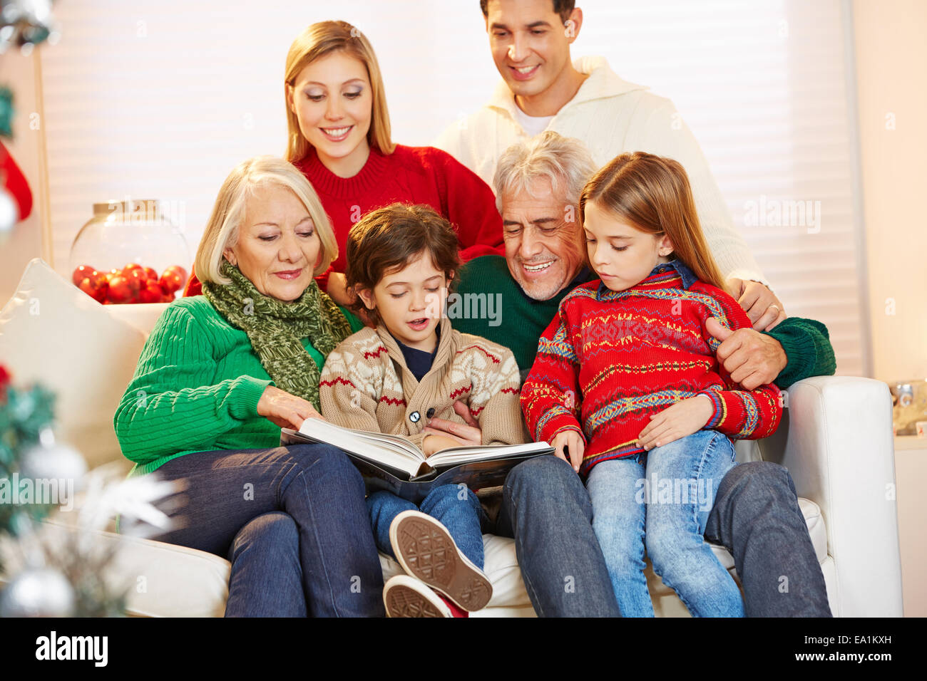 Grandparents reading book to grandchildren at christmas Stock Photo - Alamy