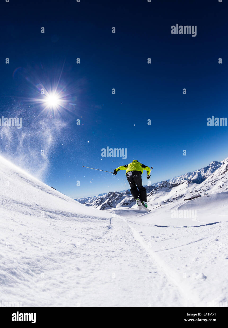 Alpine skier skiing downhill, blue sky on background Stock Photo - Alamy