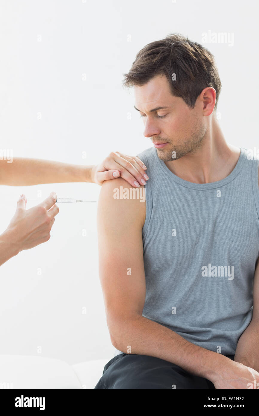Doctor injecting man on arm in clinic Stock Photo - Alamy