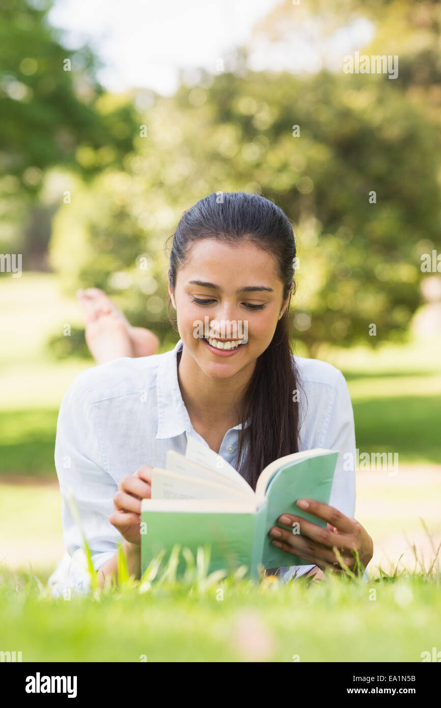 Smiling woman reading a book in park Stock Photo - Alamy