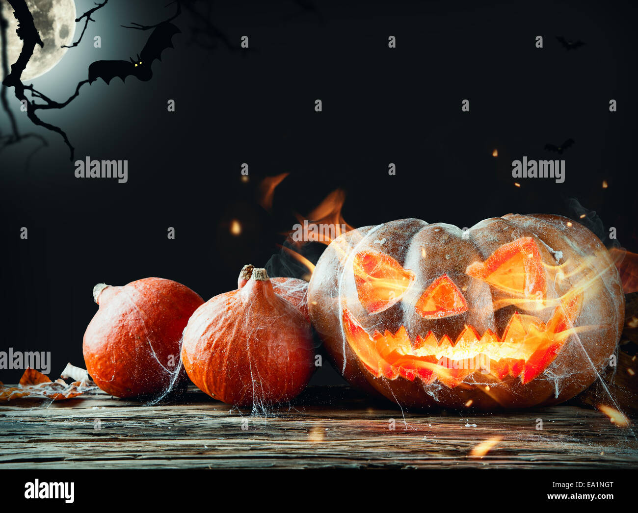 Halloween pumpkin with fire flames on wooden planks. Shinning moon on ...