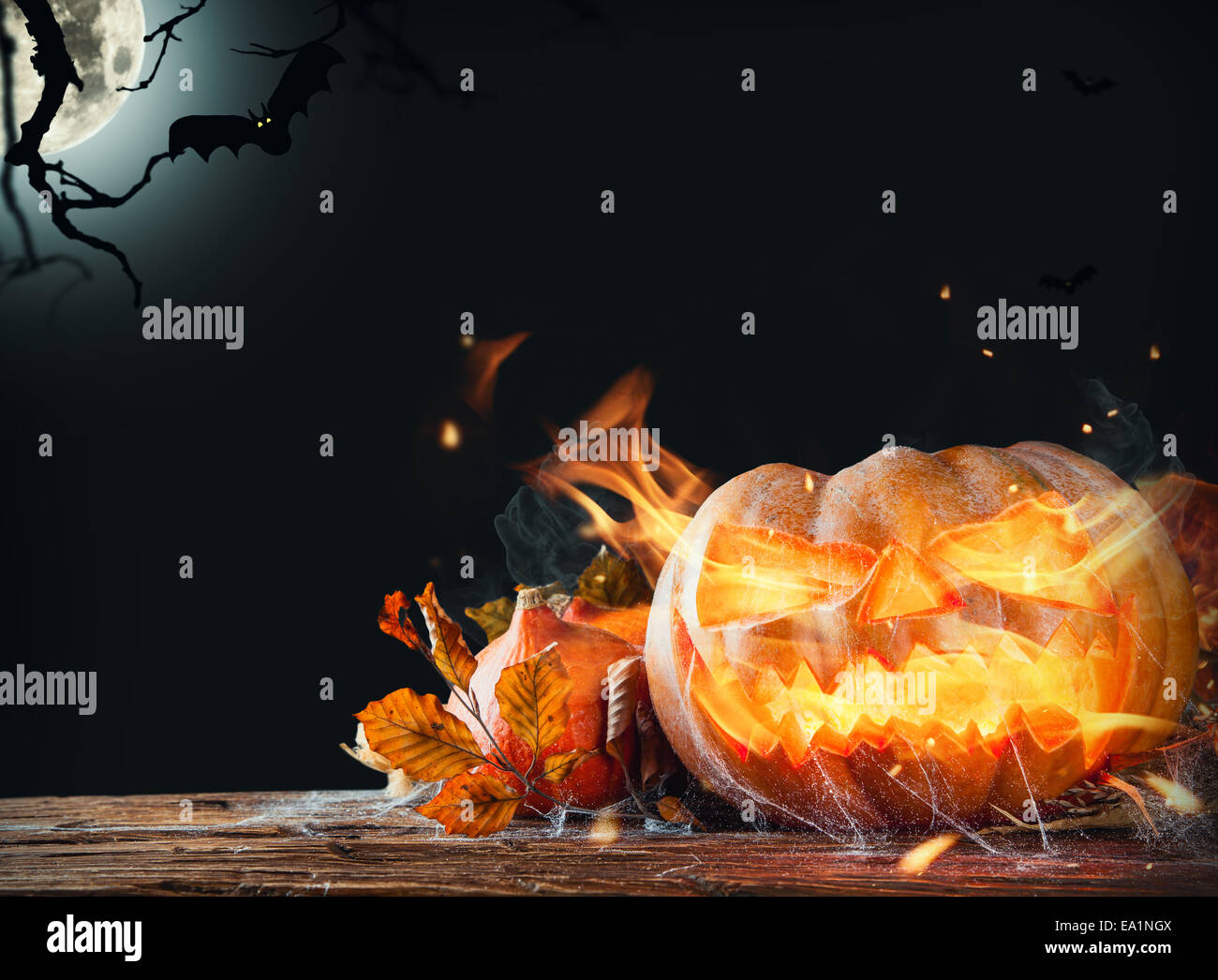 Halloween pumpkin with fire flames on wooden planks. Shinning moon on ...