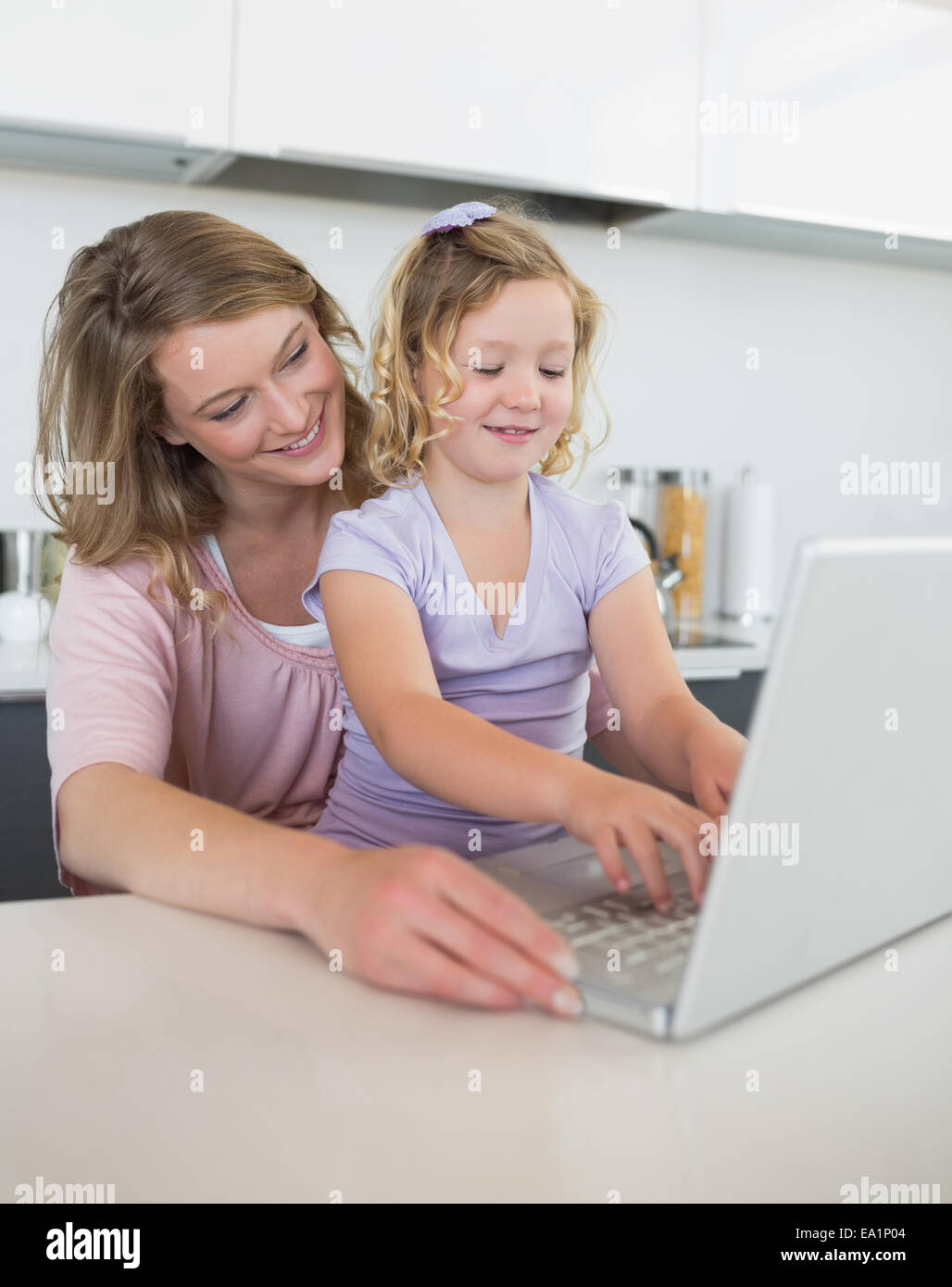 Mother and daughter using laptop together Stock Photo - Alamy