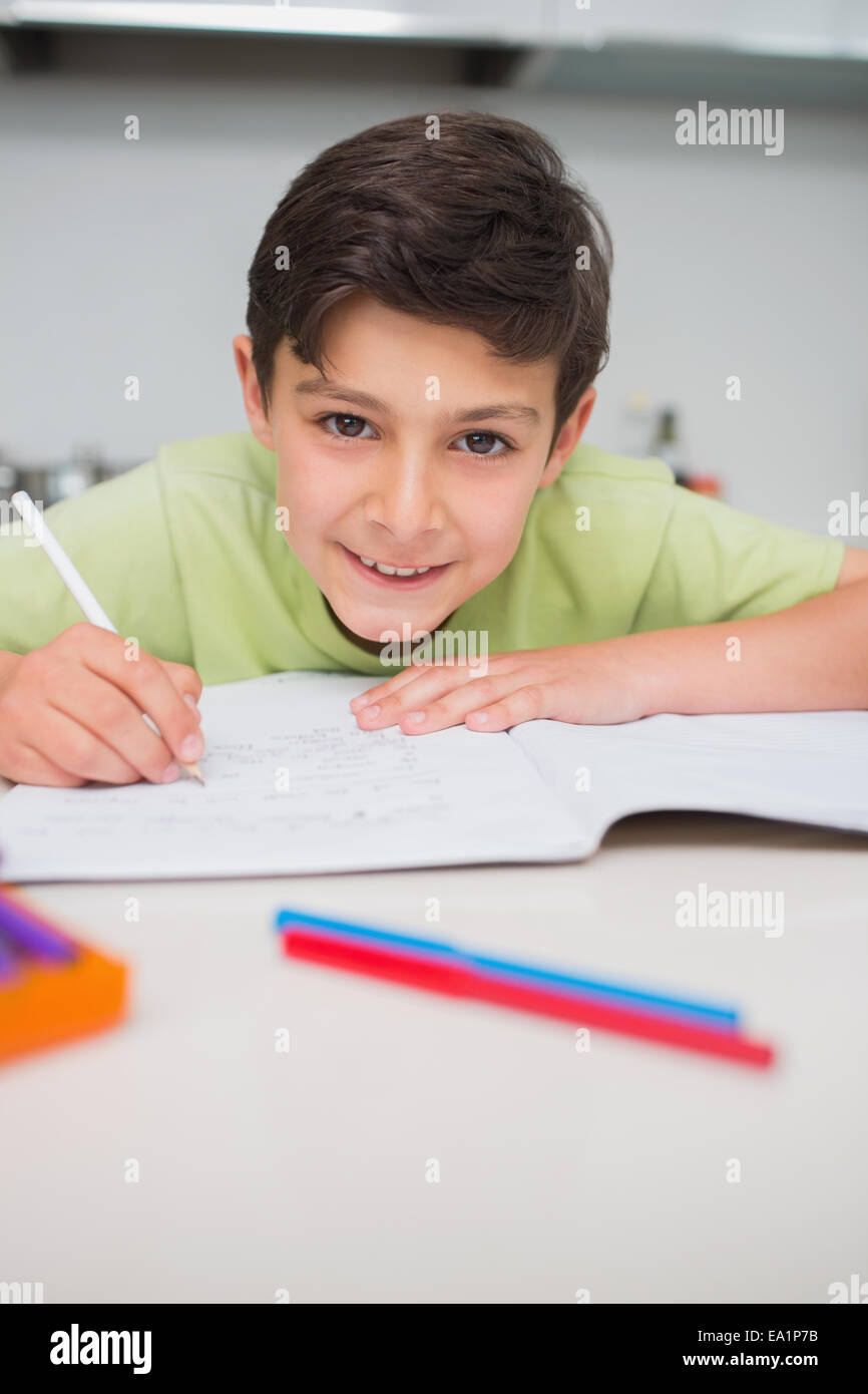 Smiling boy doing homework in kitchen Stock Photo - Alamy