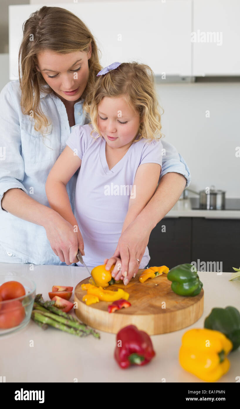 Mother assisting girl in chopping capsicum Stock Photo - Alamy
